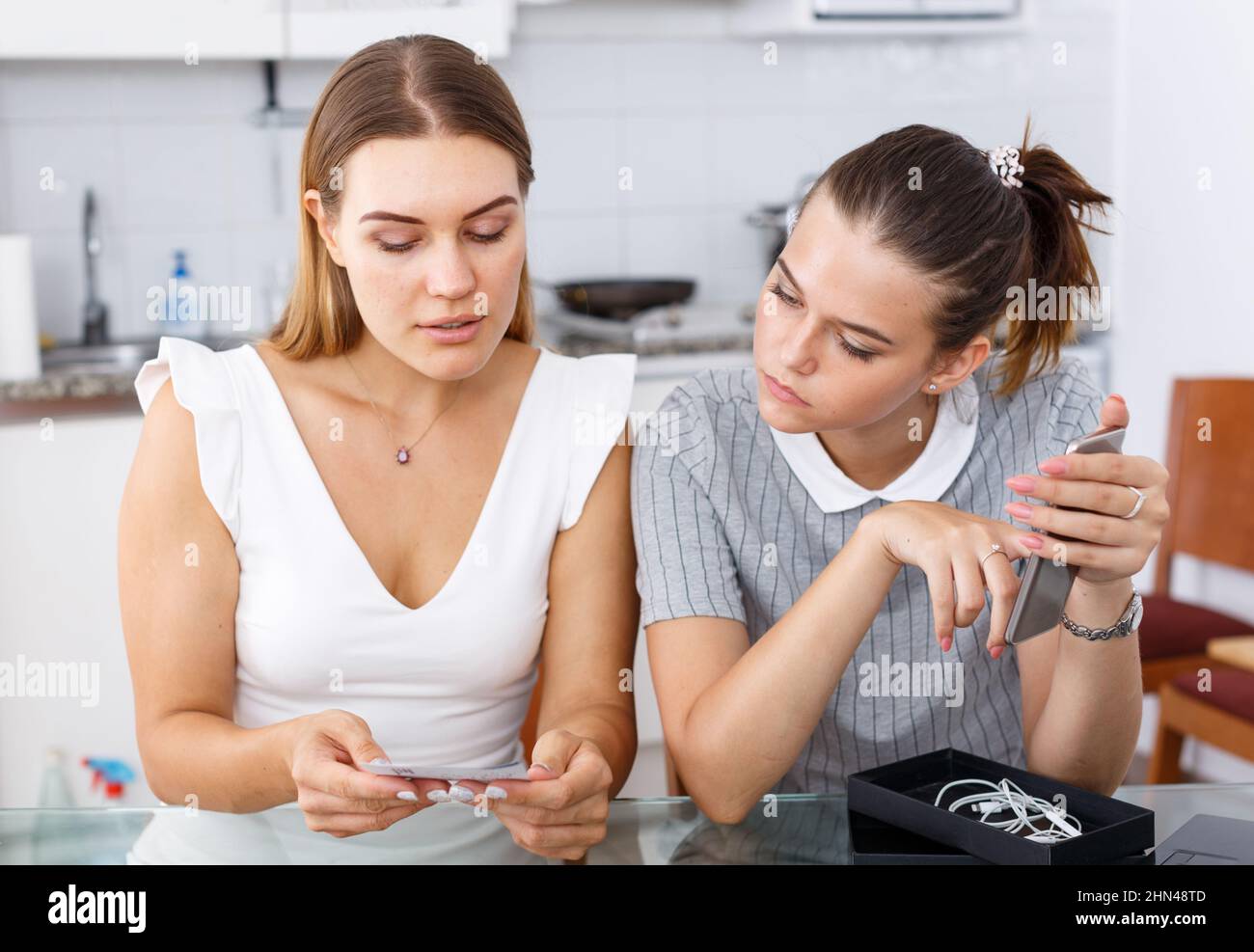 Girls who reading smartphone manual Stock Photo - Alamy