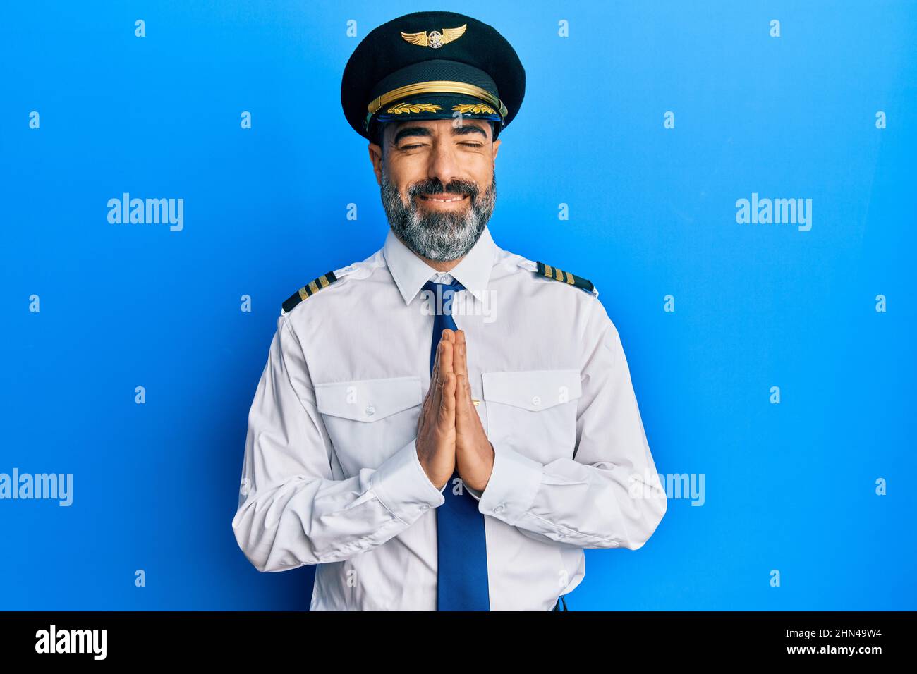 Middle age man with beard and grey hair wearing airplane pilot uniform ...