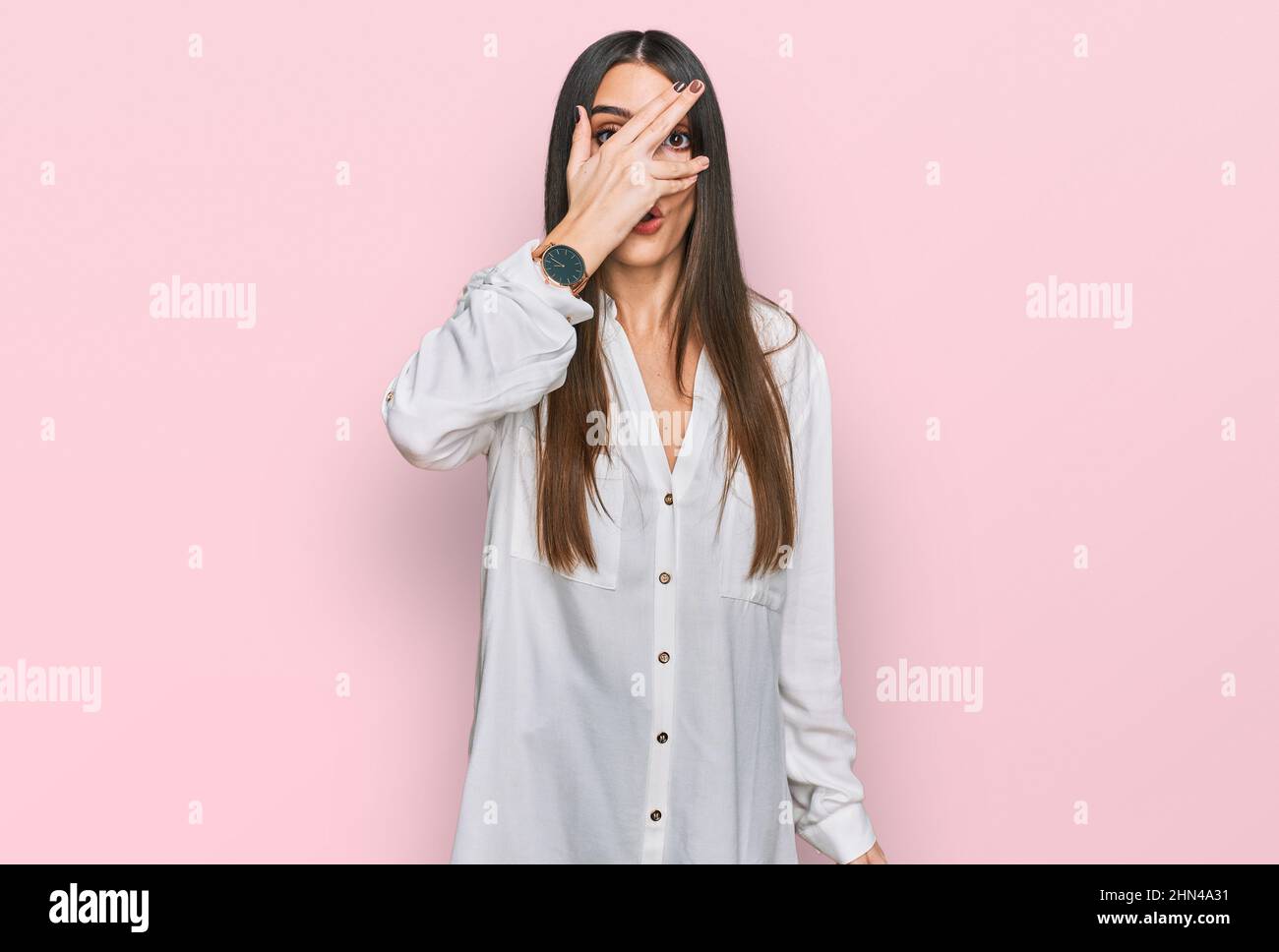 Young Beautiful Woman Wearing Casual White Shirt Peeking In Shock