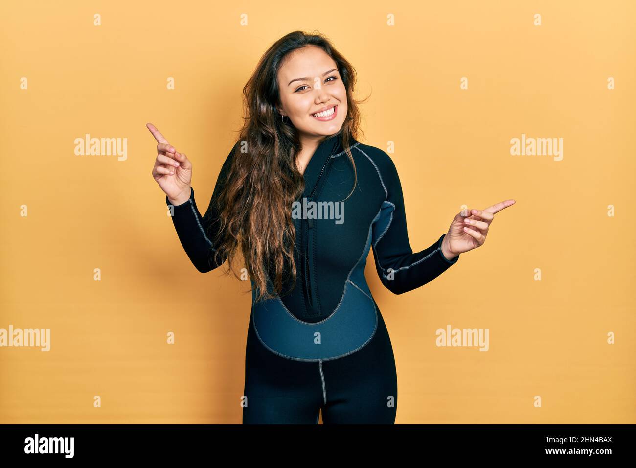 Young hispanic girl wearing diver neoprene uniform smiling confident ...