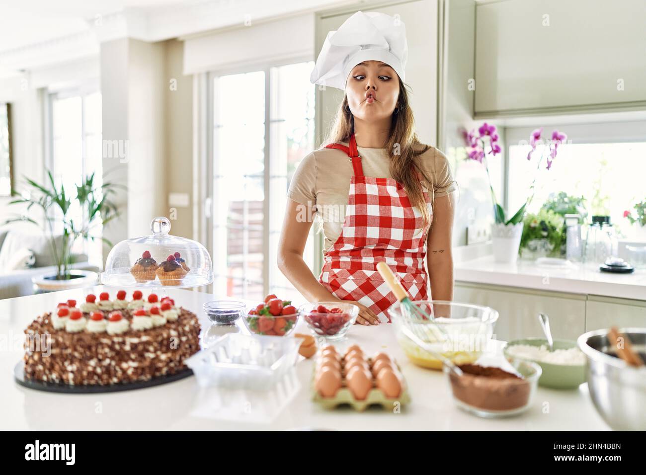 Beautiful young brunette pastry chef woman cooking pastries at the ...