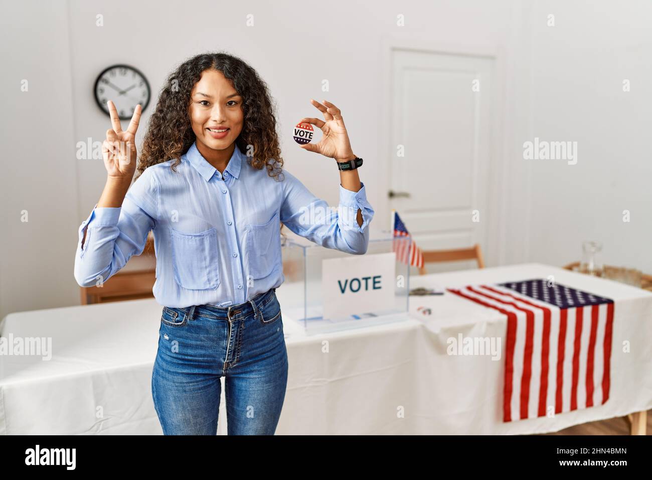 Beautiful hispanic woman standing by at political campaign by voting ...