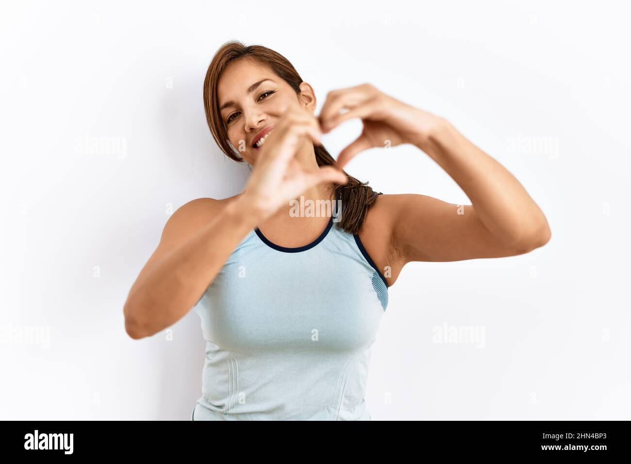 Young latin woman wearing sporty clothes over isolated background ...
