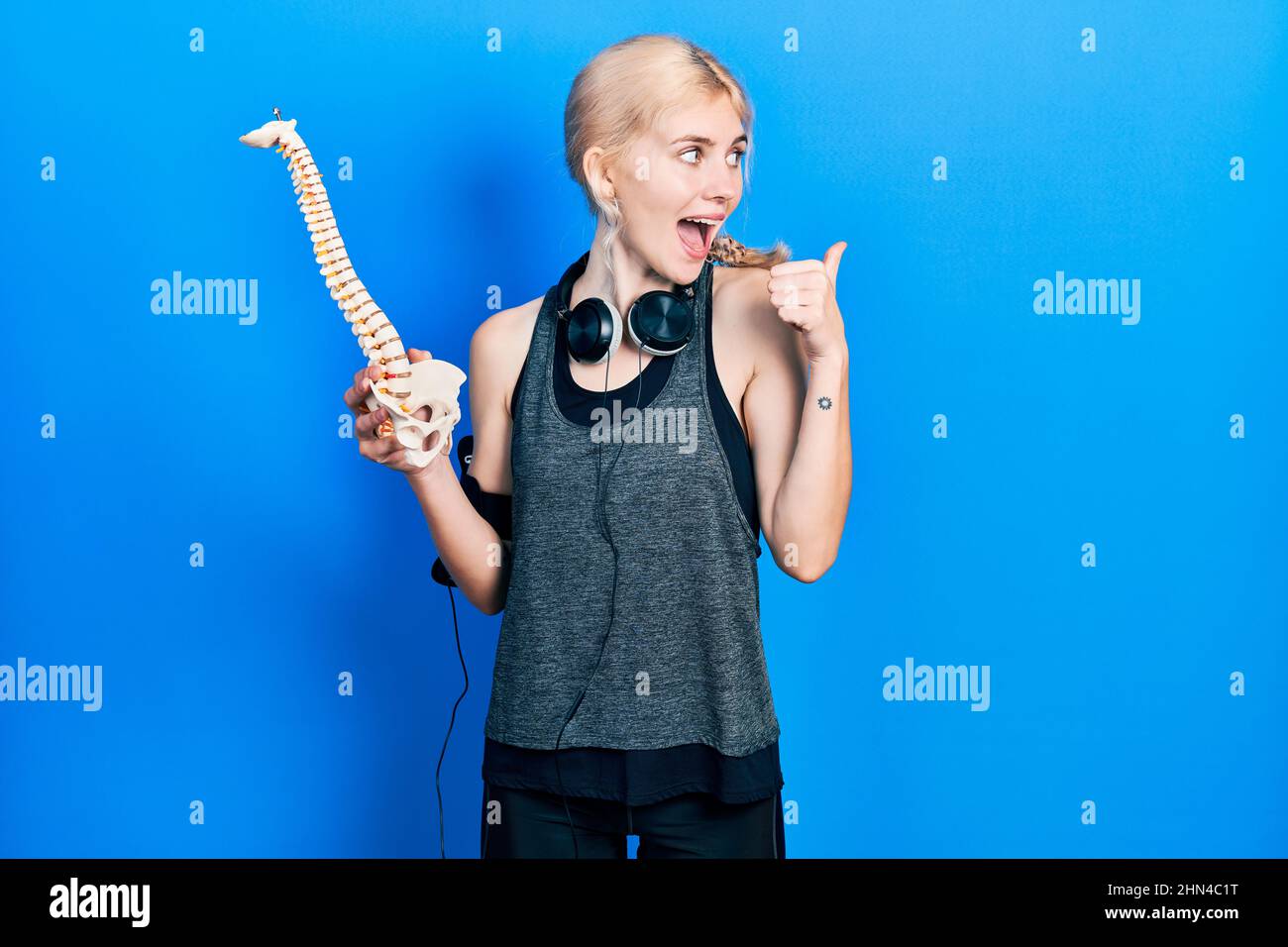 Beautiful caucasian sports woman with blond hair holding anatomical ...