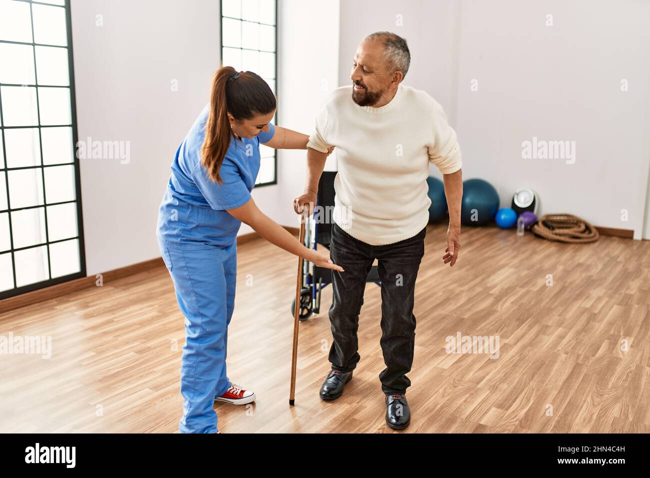 Senior man sitting on wheelchair being assited by geriatric nurse ...