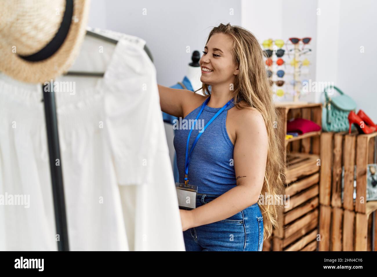 Young blonde girl shopkeeper working at clothing store Stock Photo - Alamy