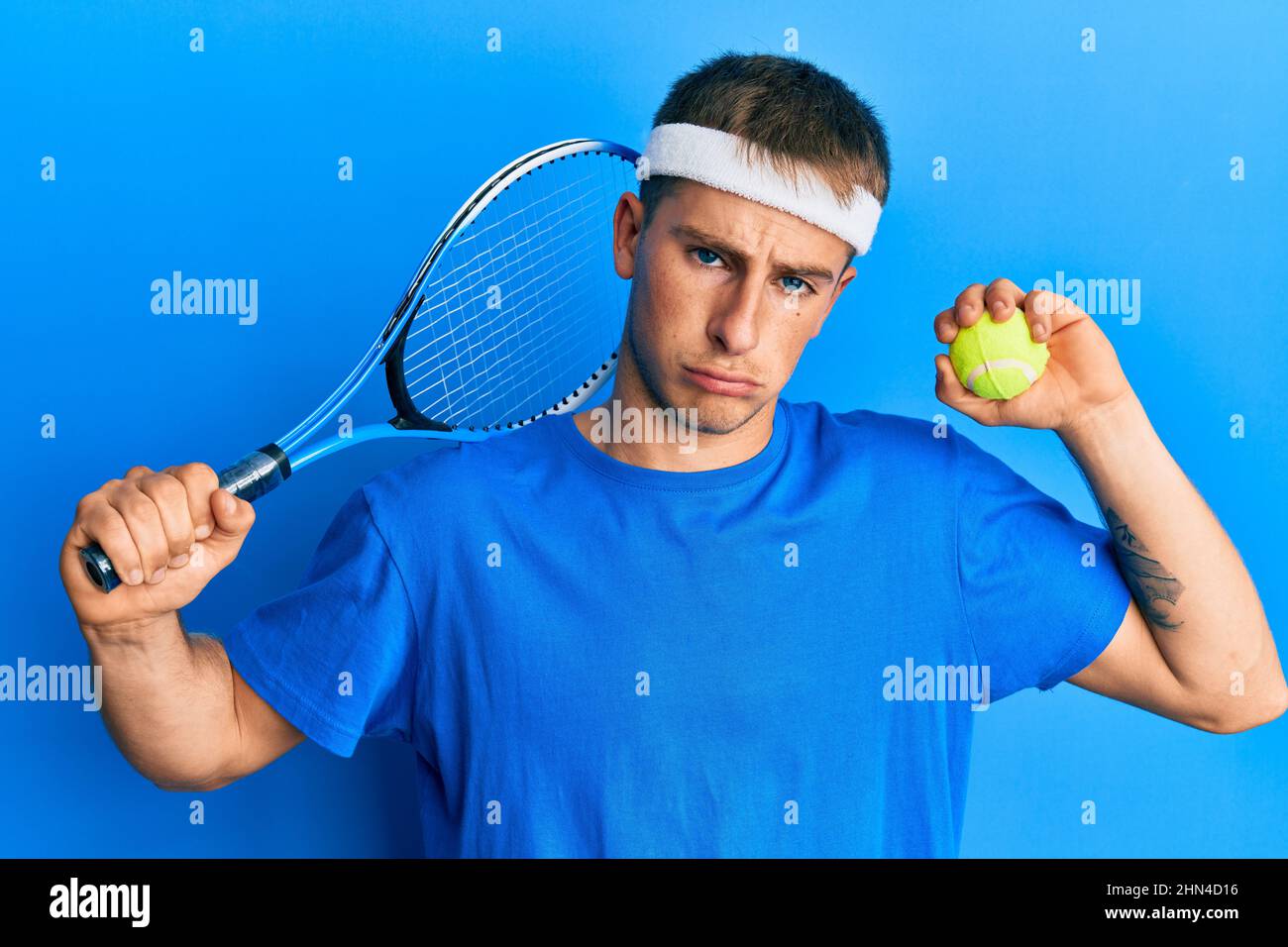 Young caucasian man playing tennis holding racket and ball depressed ...