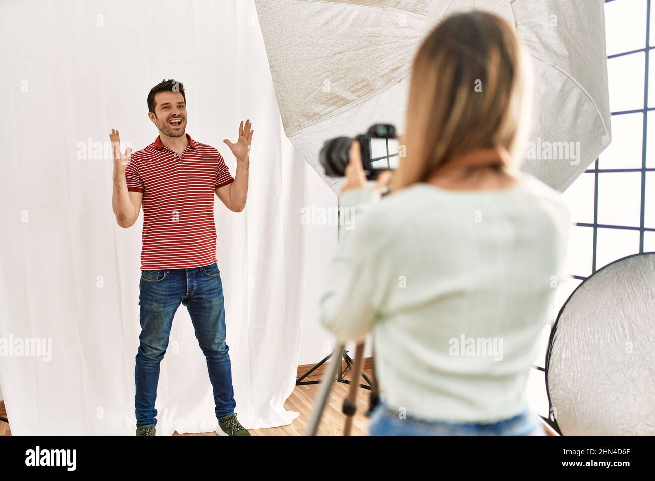 Woman photographer talking pictures of man posing as model at ...