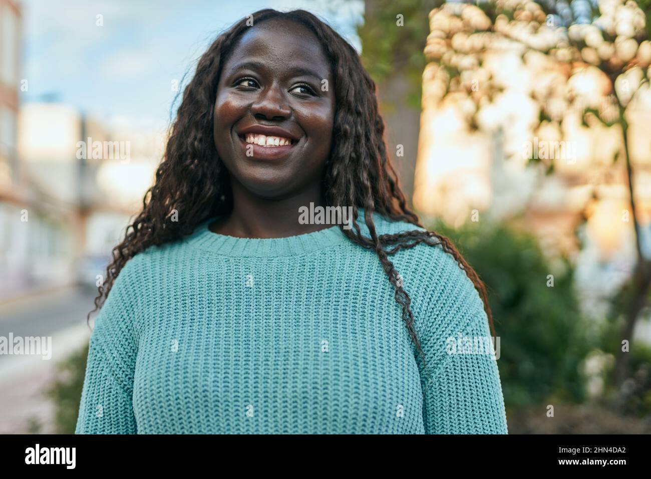 Young african woman smiling happy at the city Stock Photo - Alamy