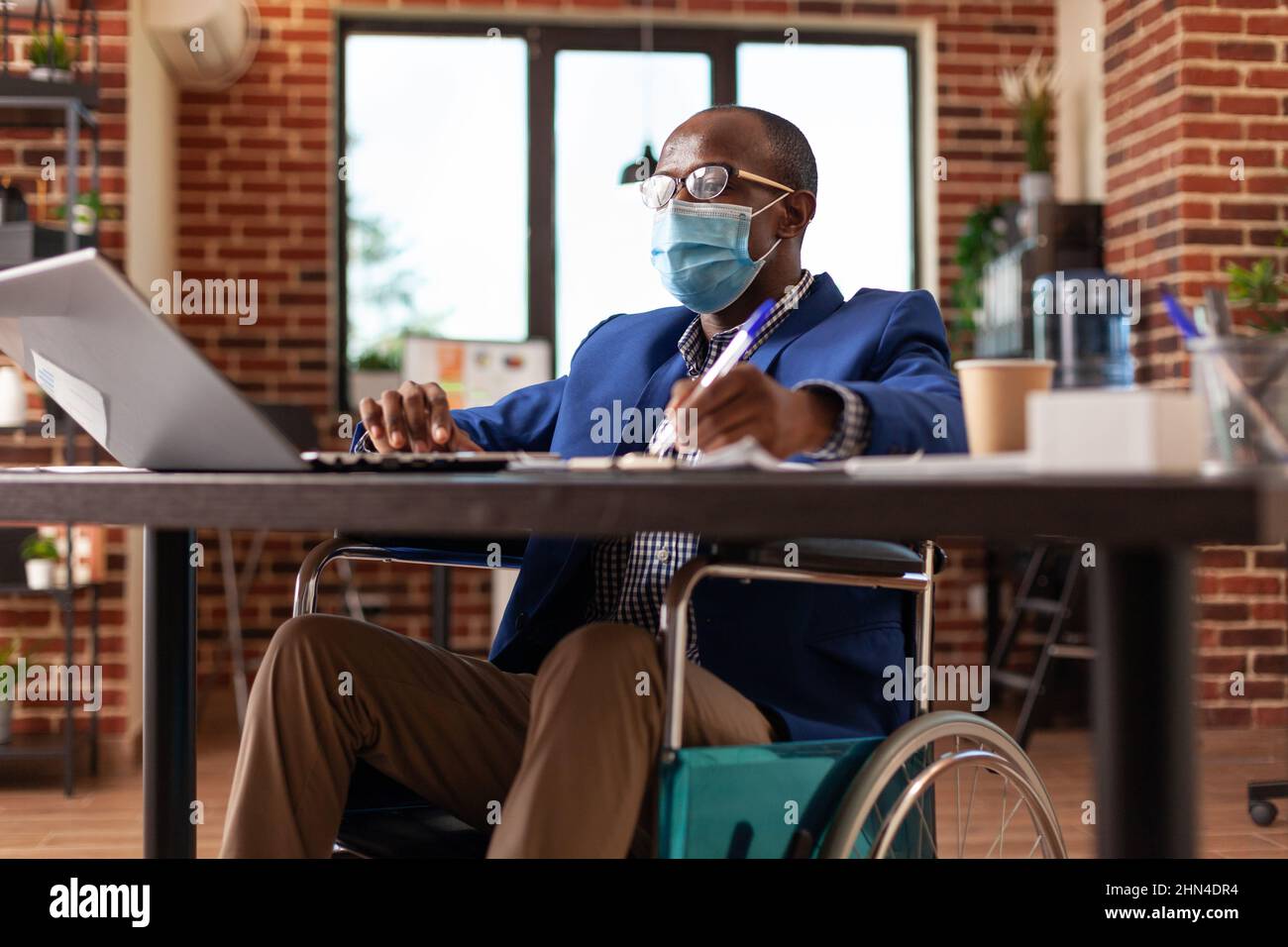 Close up of entrepreneur with disability working with laptop on ...