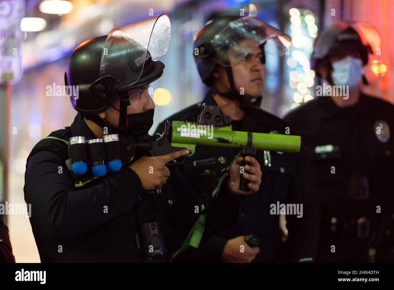 Los Angeles Police officers in riot gear aim 40mm less-lethal ...