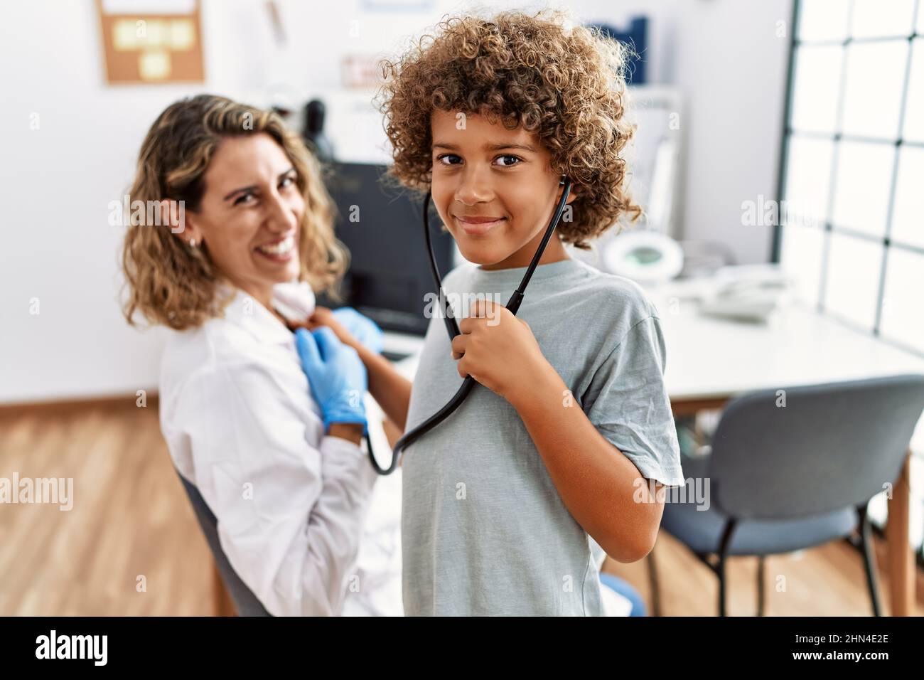 Mother and son child auscultating doctor chest at clinic Stock Photo ...