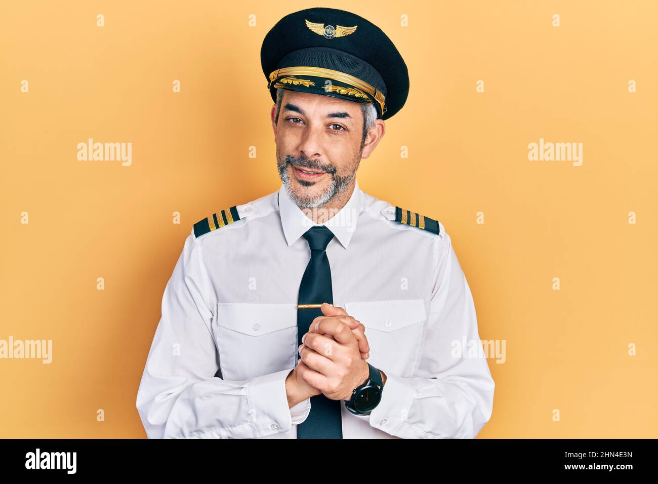 Handsome middle age man with grey hair wearing airplane pilot uniform ...