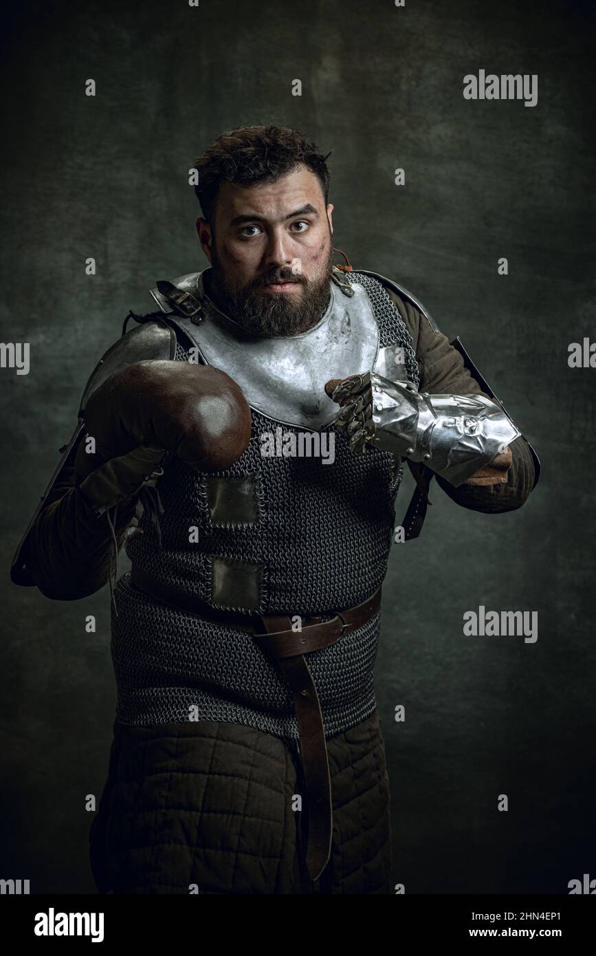 Portrait of medieval warrior or knight with dirty wounded face boxing ...