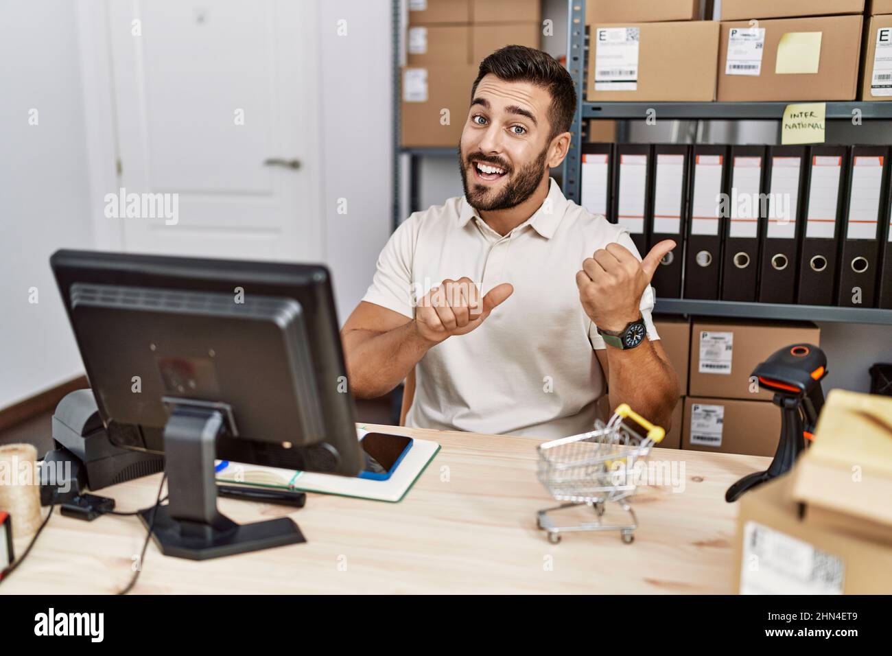 Handsome hispanic man working at small business commerce pointing to ...