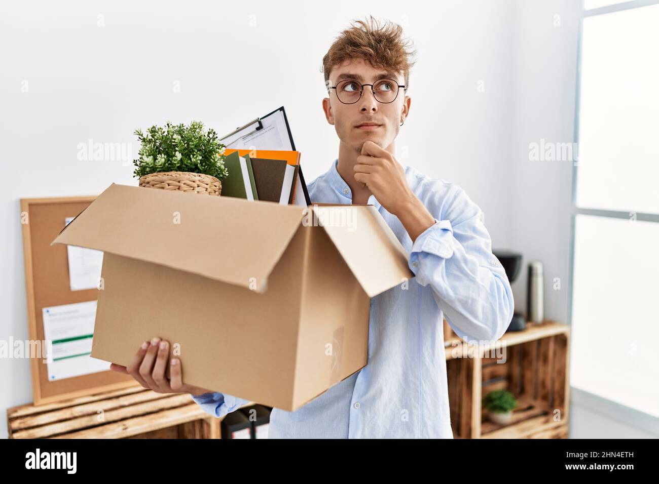 Young caucasian man holding business box serious face thinking about ...