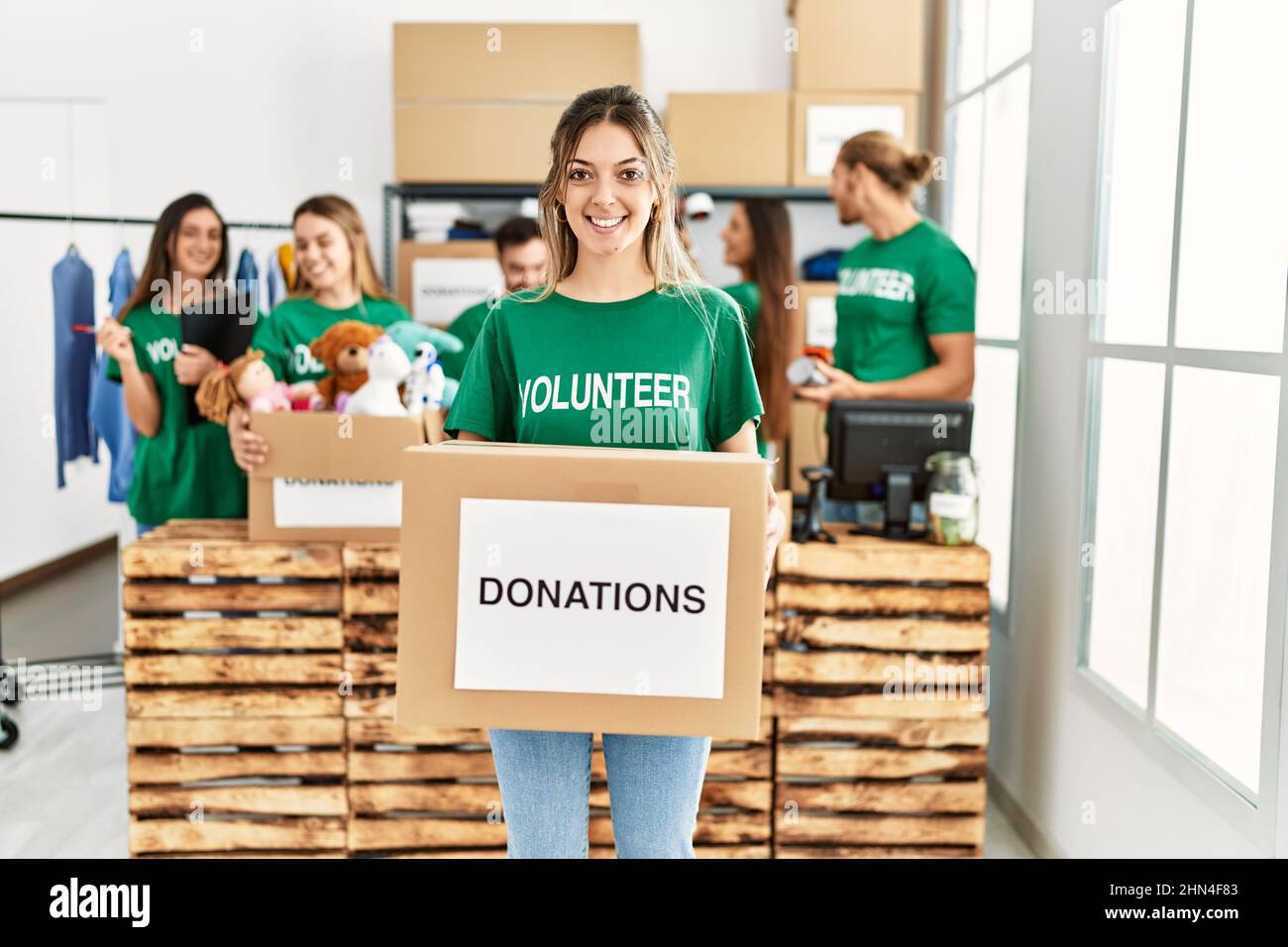 Group of young volunteers working at charity center. Man smiling happy ...