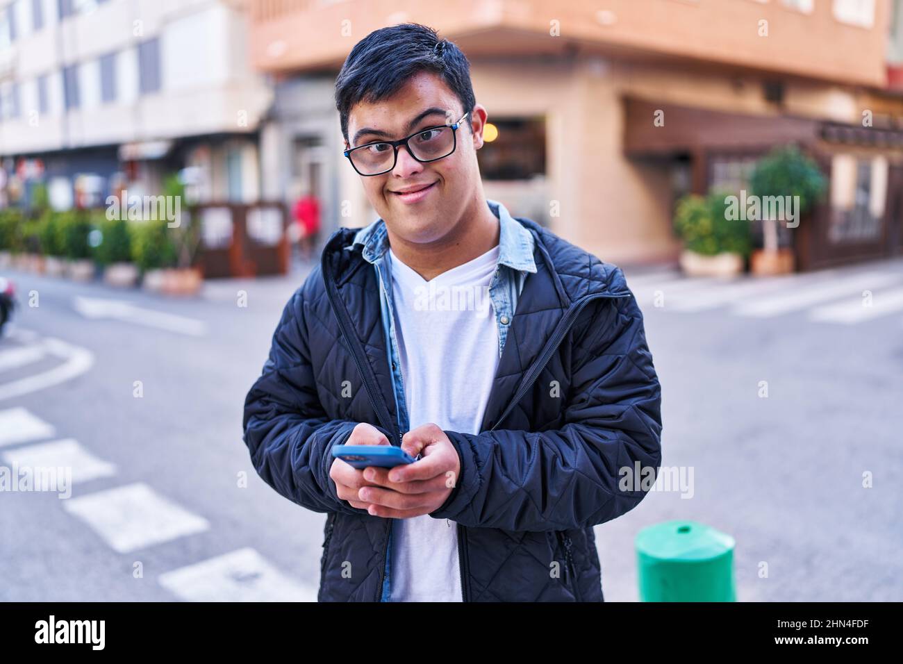 Down syndrome man smiling confident using smartphone at street Stock ...