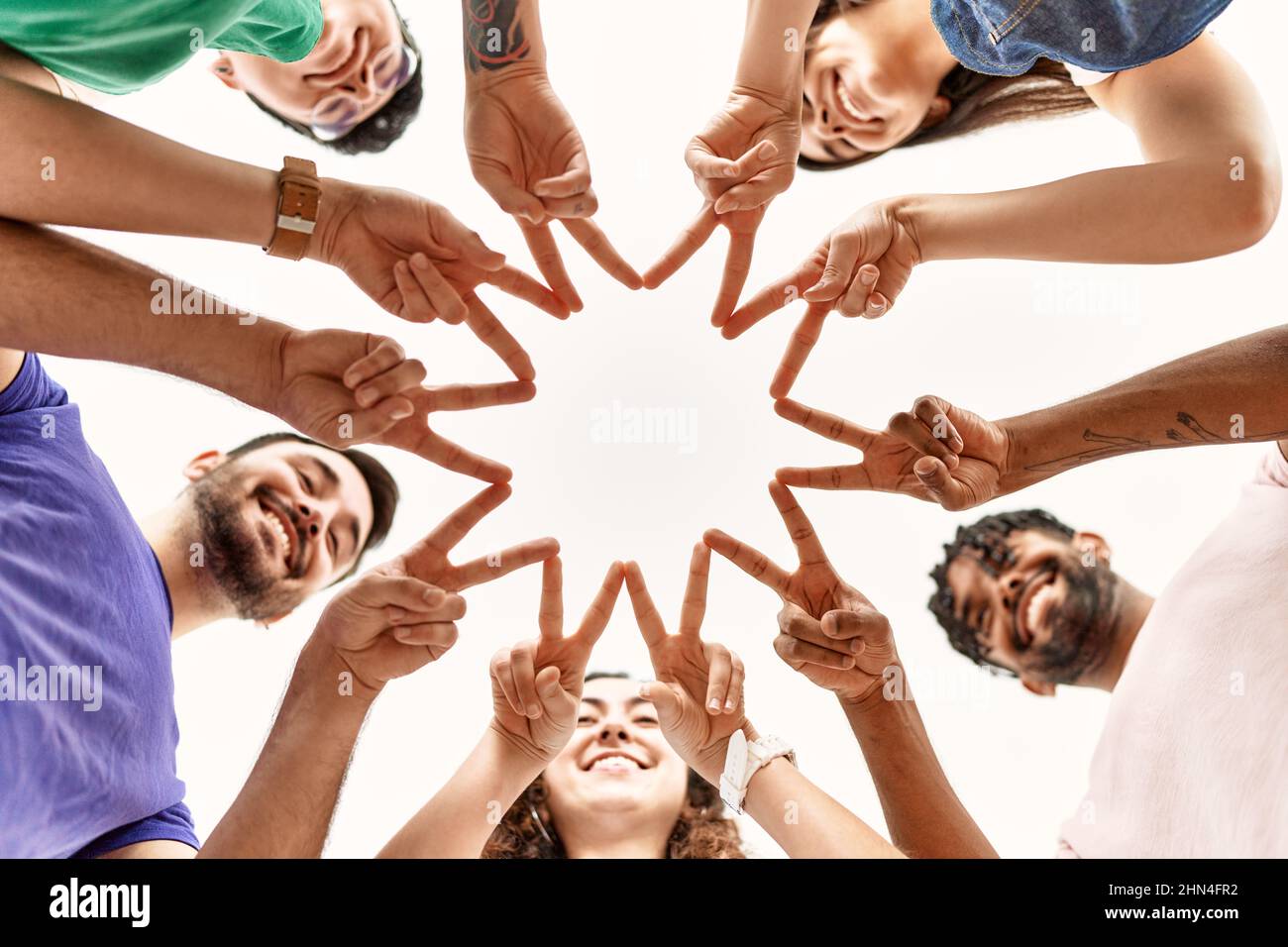 Group of young friends doing victory sign with fingers and hands ...