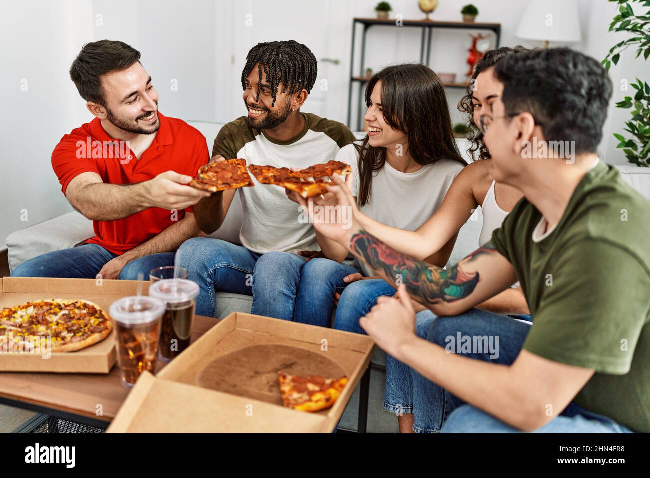 Group of young friends smiling happy eating italian pizza sitting on ...