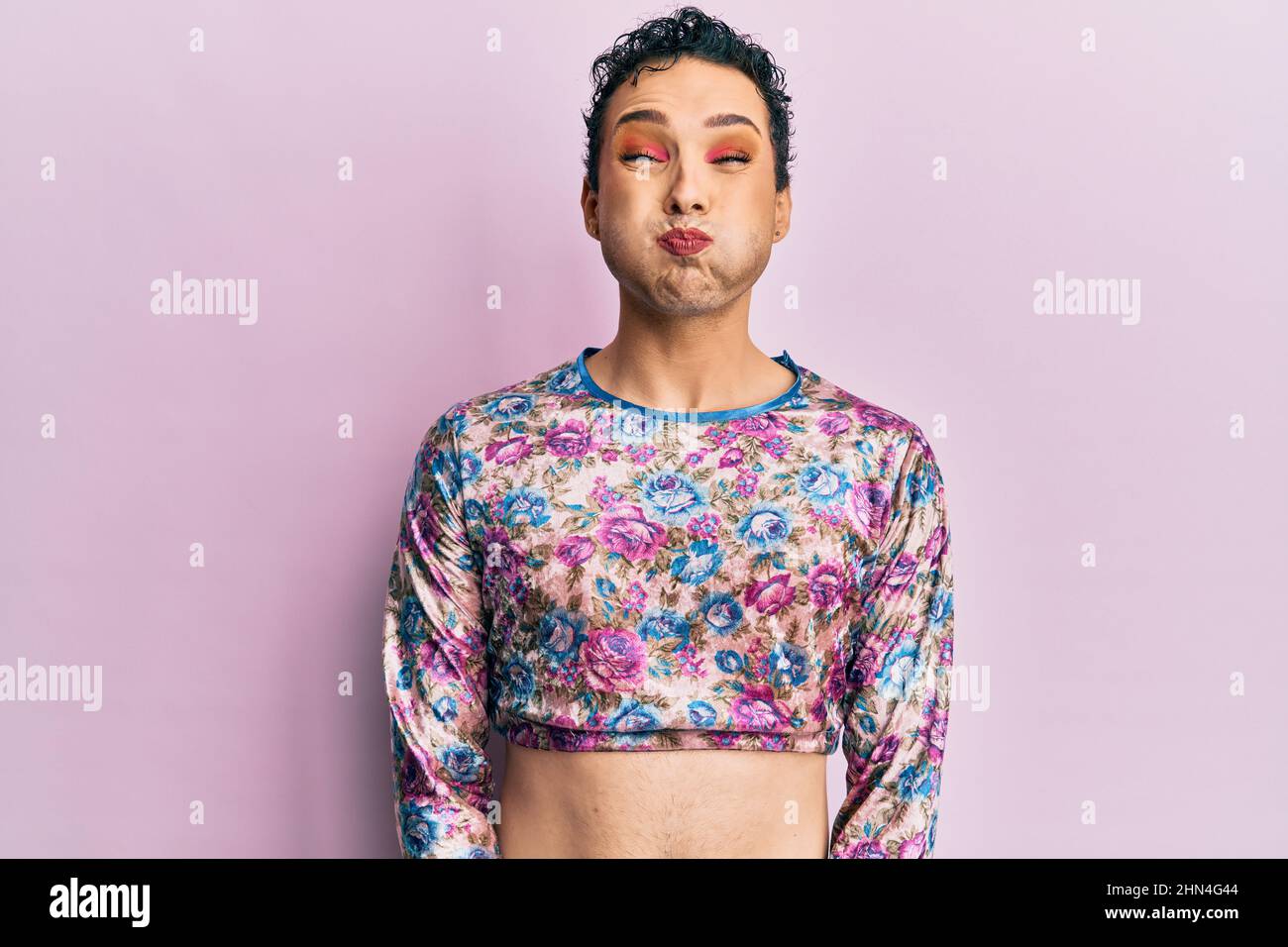 Handsome man wearing make up wearing fashion clothes puffing cheeks ...