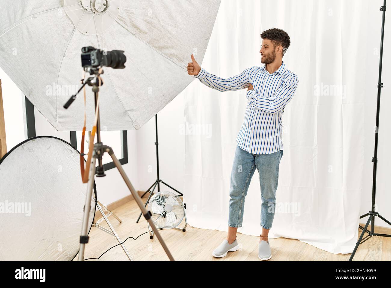 Arab young man posing as model at photography studio looking proud ...
