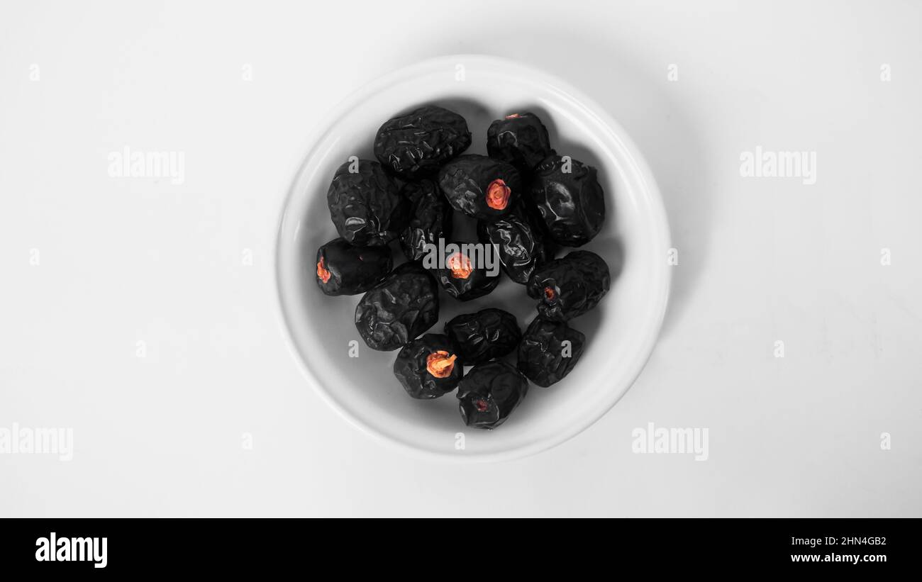 a plate of ajwa dates in a white background Stock Photo - Alamy