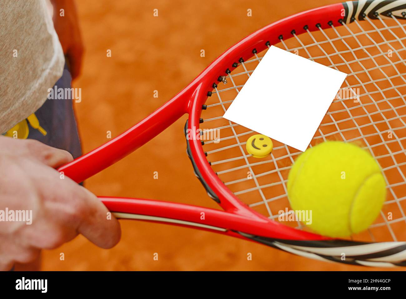 Male player holding tennis ball and racket on tennis court with blank ...