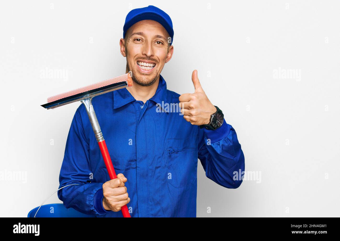 Bald man with beard wearing glass cleaner uniform and squeegee smiling ...