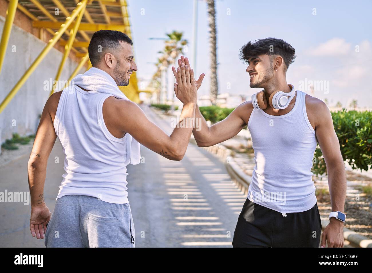 Two hispanic men couple smiling confident high five with hands raised ...