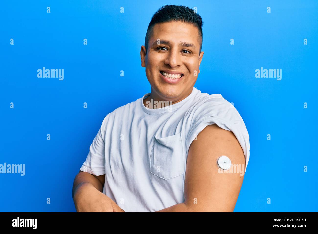 Hispanic man showing diabetes device on arm Stock Photo - Alamy