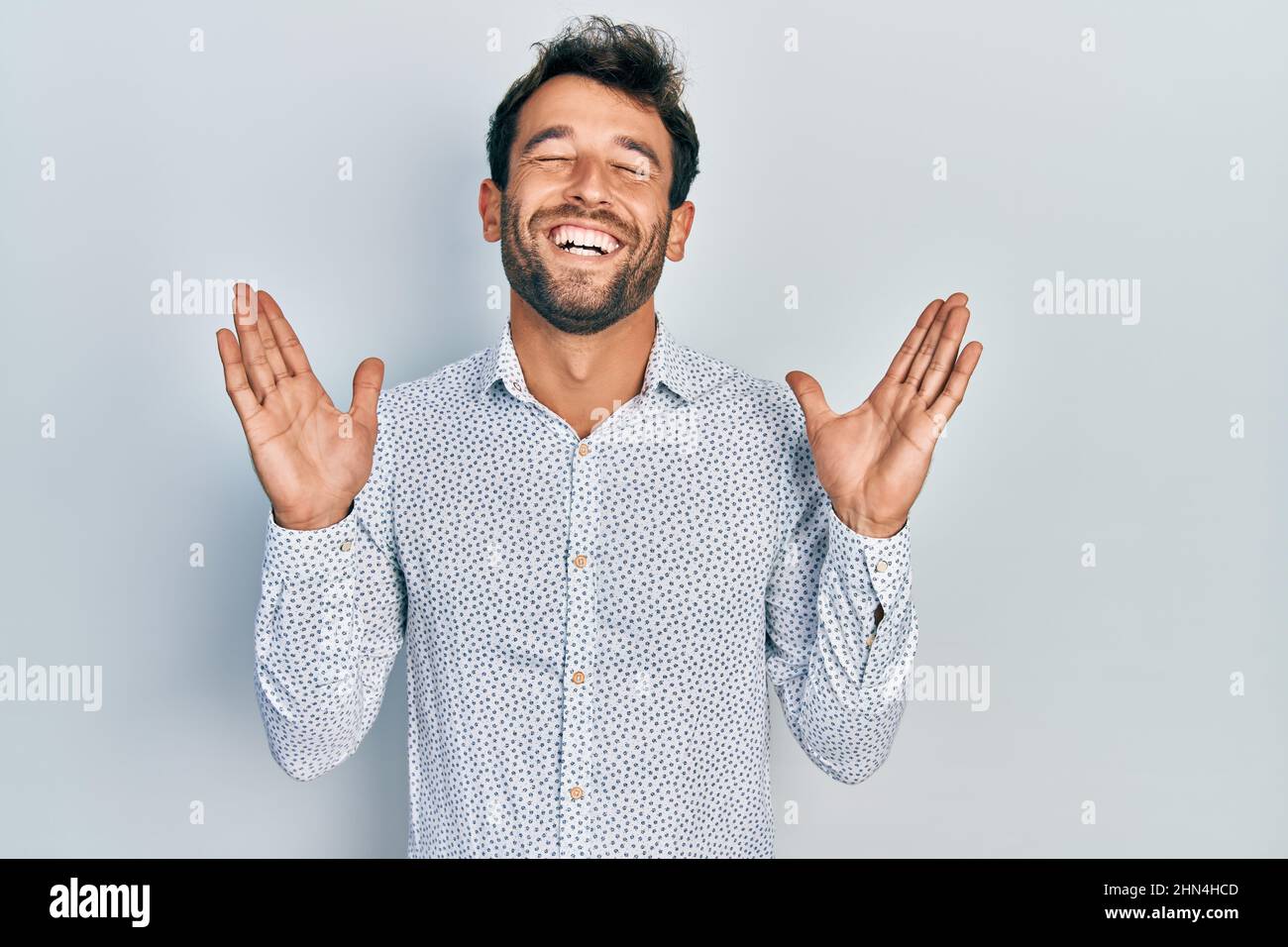Handsome man with beard wearing casual elegant shirt celebrating mad ...