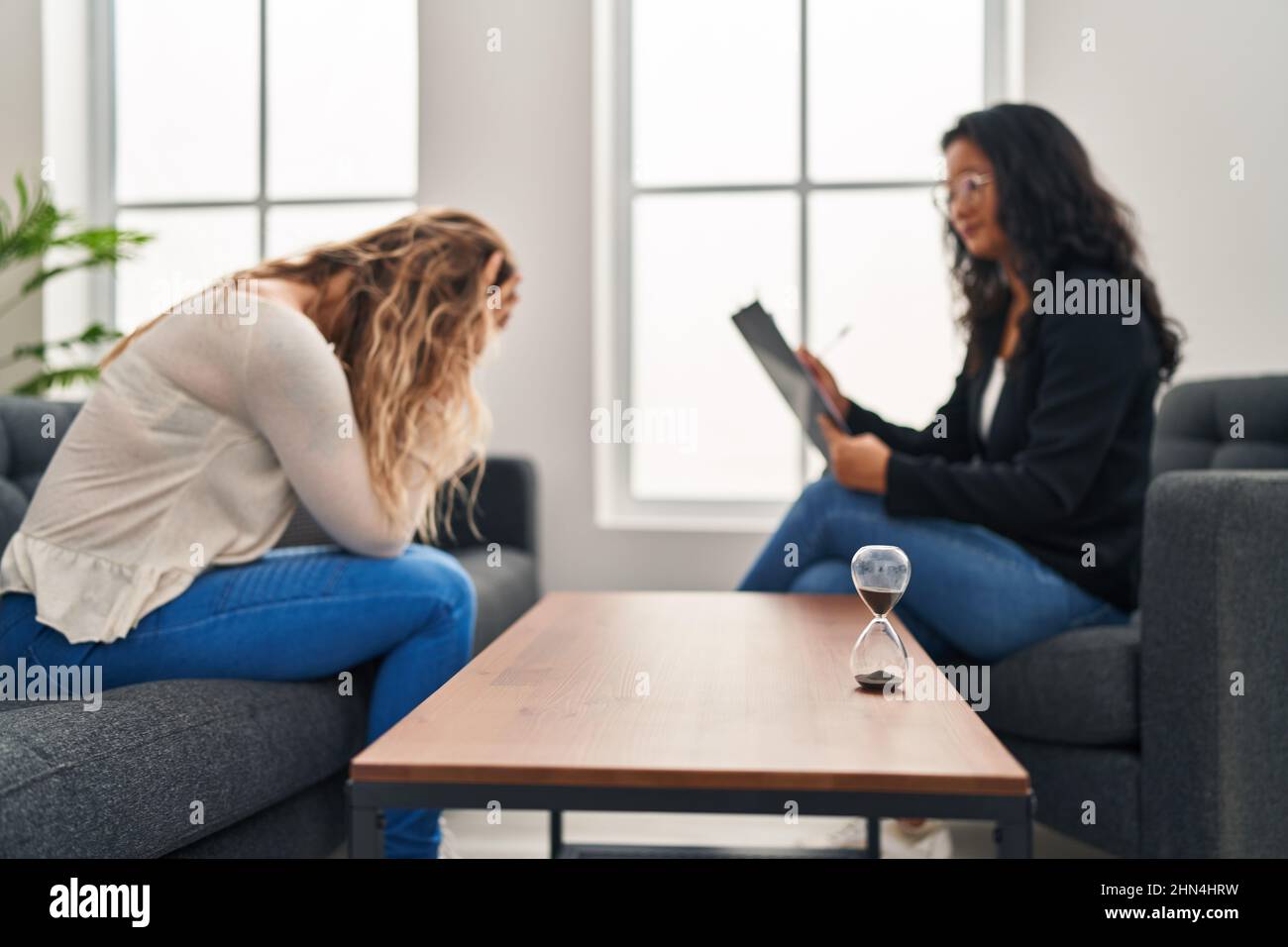 Young chinese woman psychologist and patient having psychology session ...