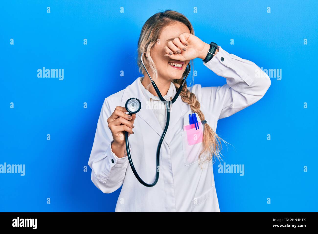 Beautiful young blonde doctor woman holding stethoscope smiling ...