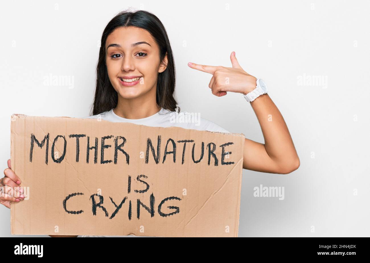 Young hispanic girl holding mother nature is crying protest cardboard ...