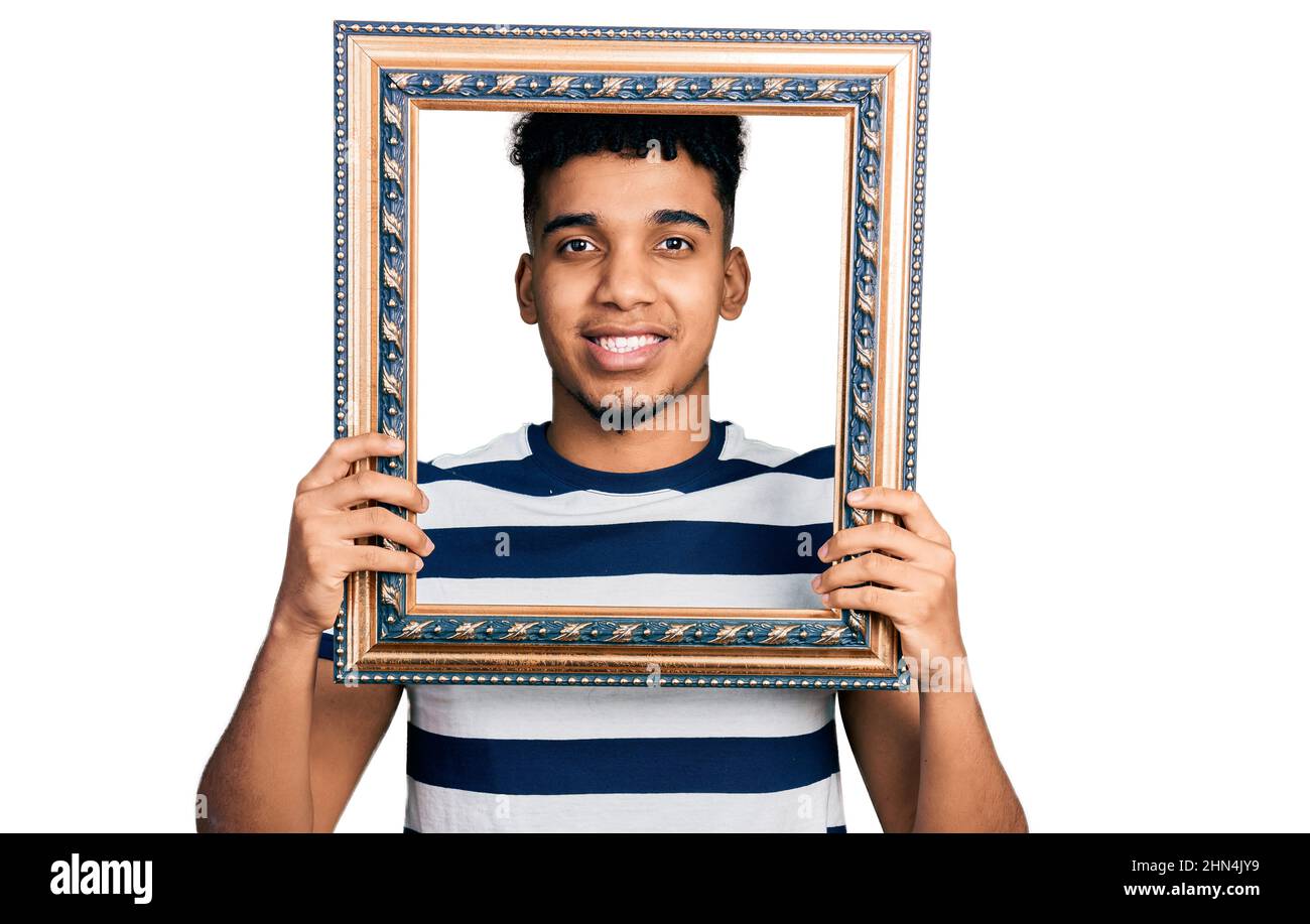Young african american man holding empty frame smiling with a happy and ...