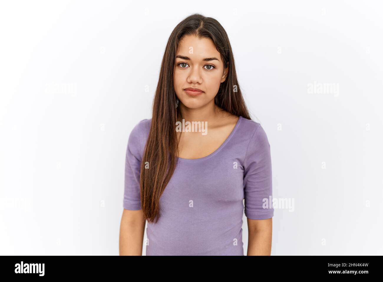 Young brunette woman standing by isolated background skeptic and ...