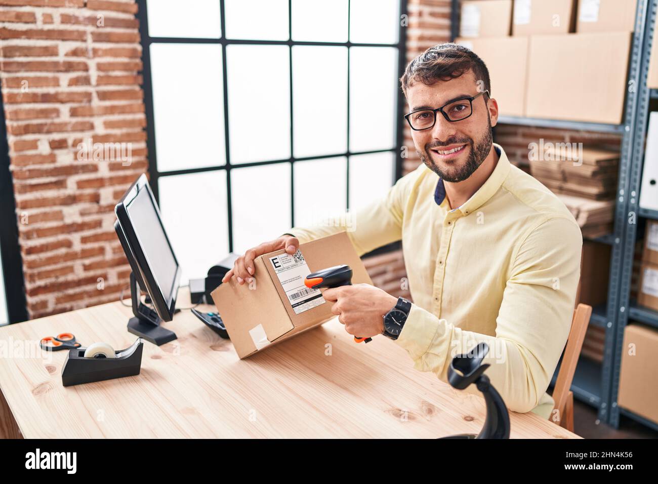 Young hispanic man ecommerce business worker scanning label using ...
