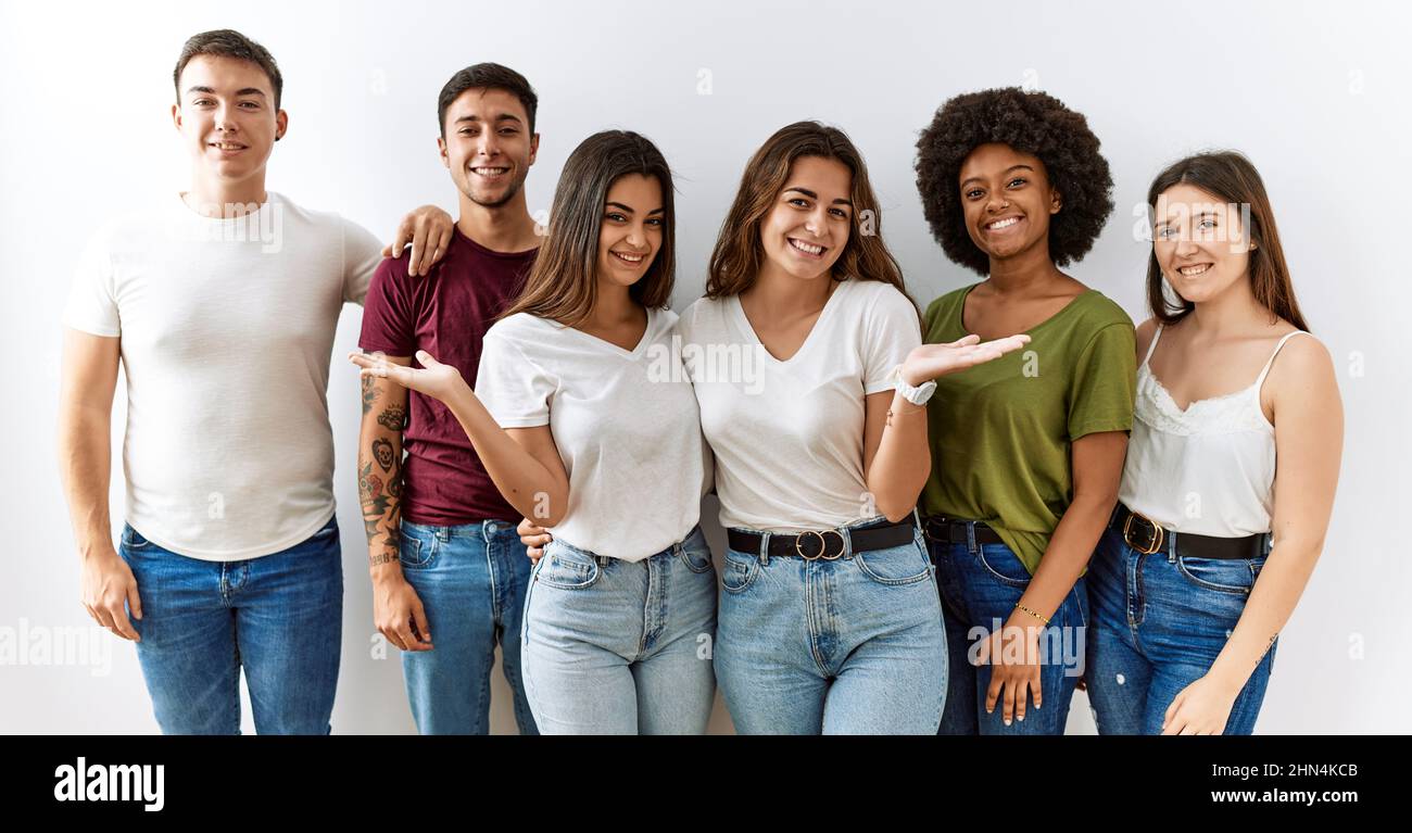 Group of young friends standing together over isolated background ...
