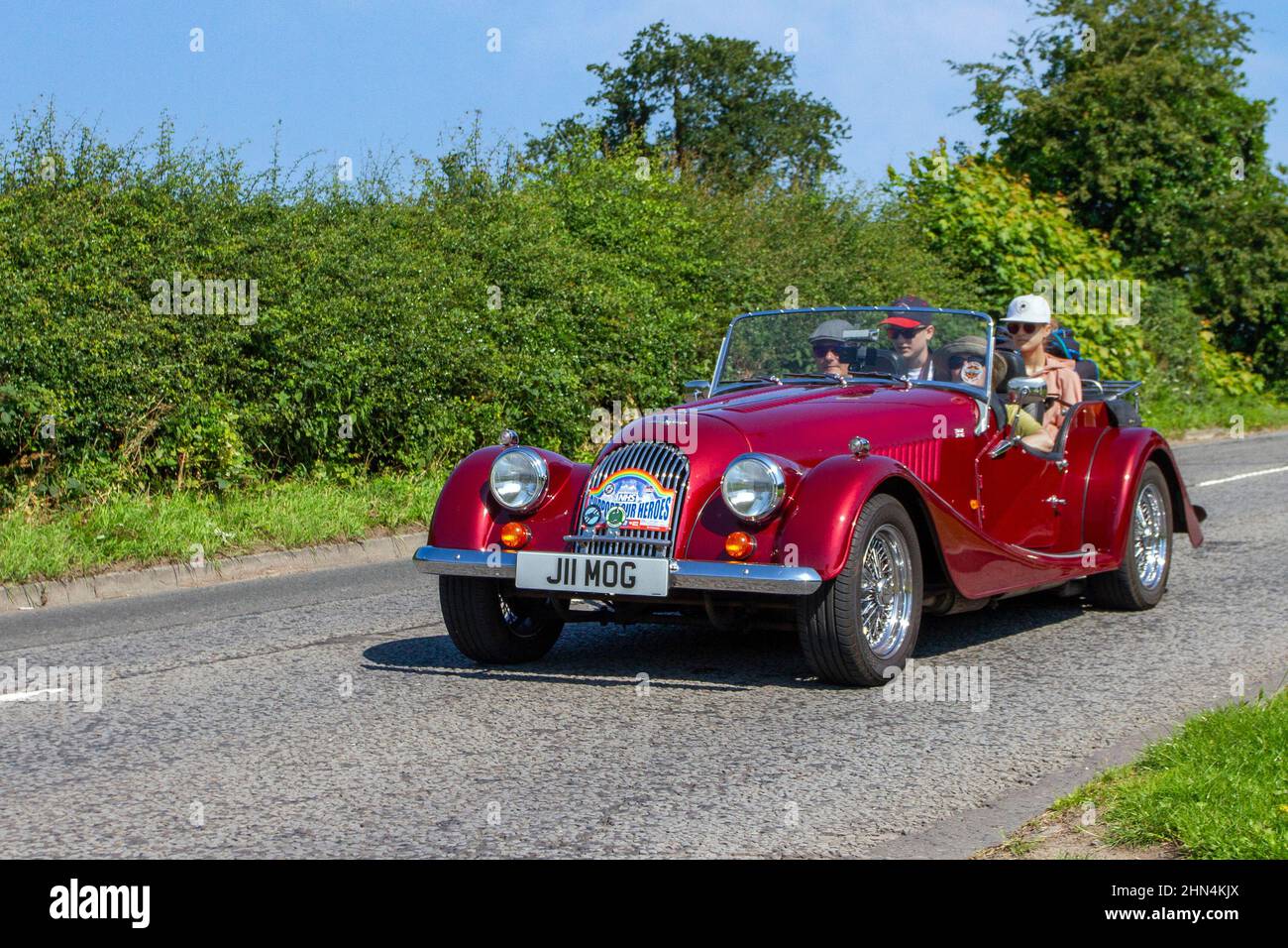 Children riding in open-topped 2008 red Morgan Roadster 2967cc petrol ...
