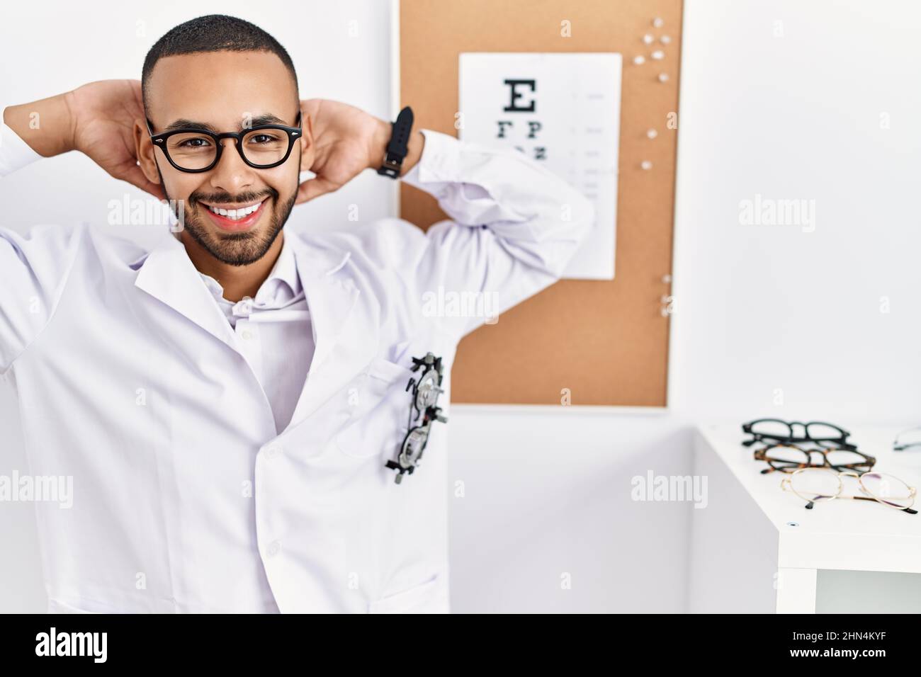 African american optician man standing by eyesight test relaxing and ...