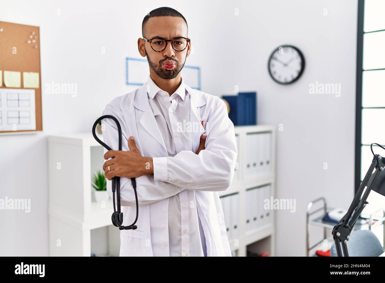 African american doctor man holding stethoscope at the clinic puffing ...