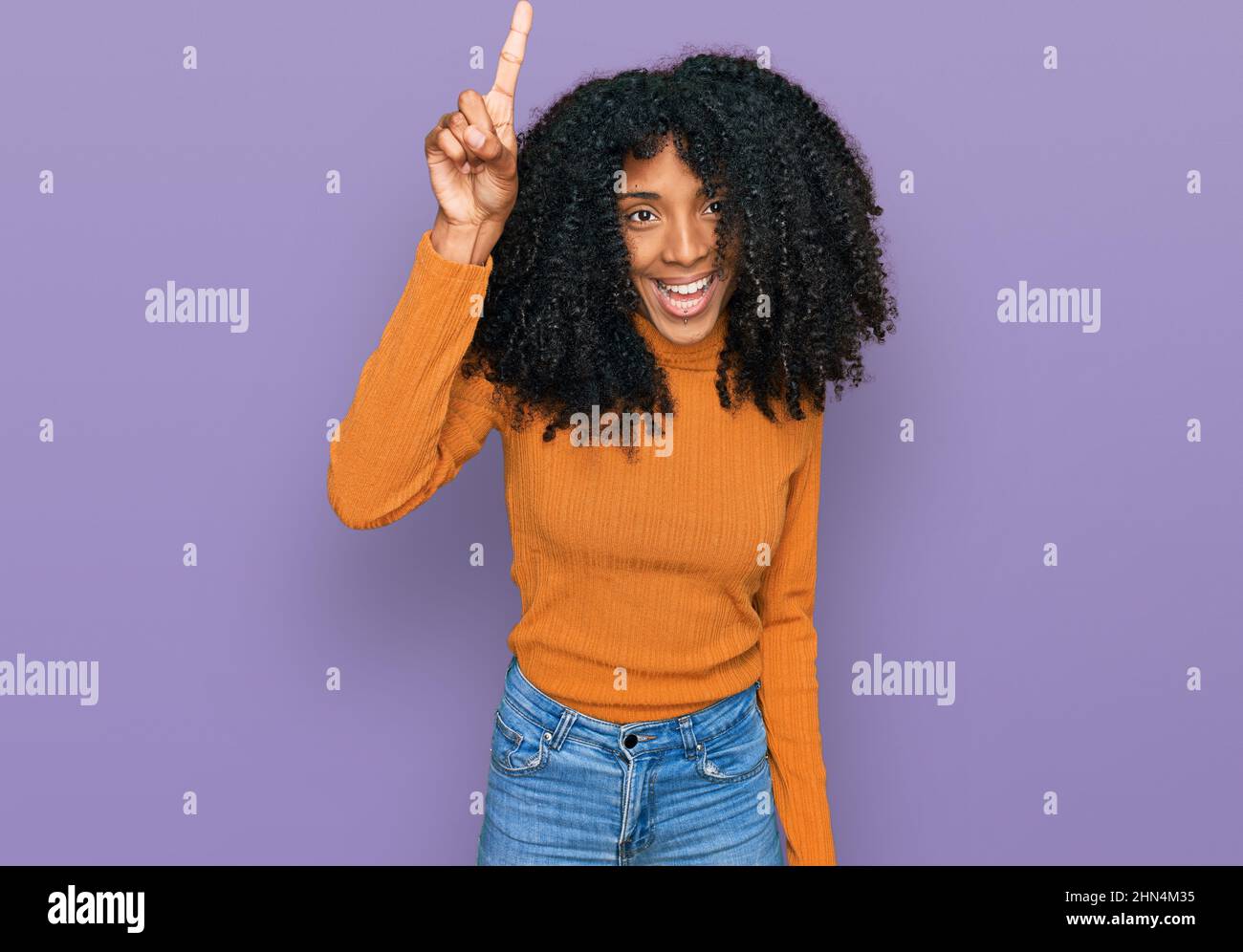 Young african american girl wearing casual clothes pointing finger up ...