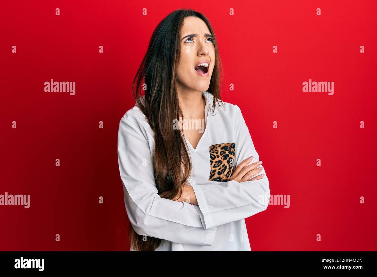 Young Hispanic Girl With Arms Crossed Gesture Angry And Mad Screaming Frustrated And Furious
