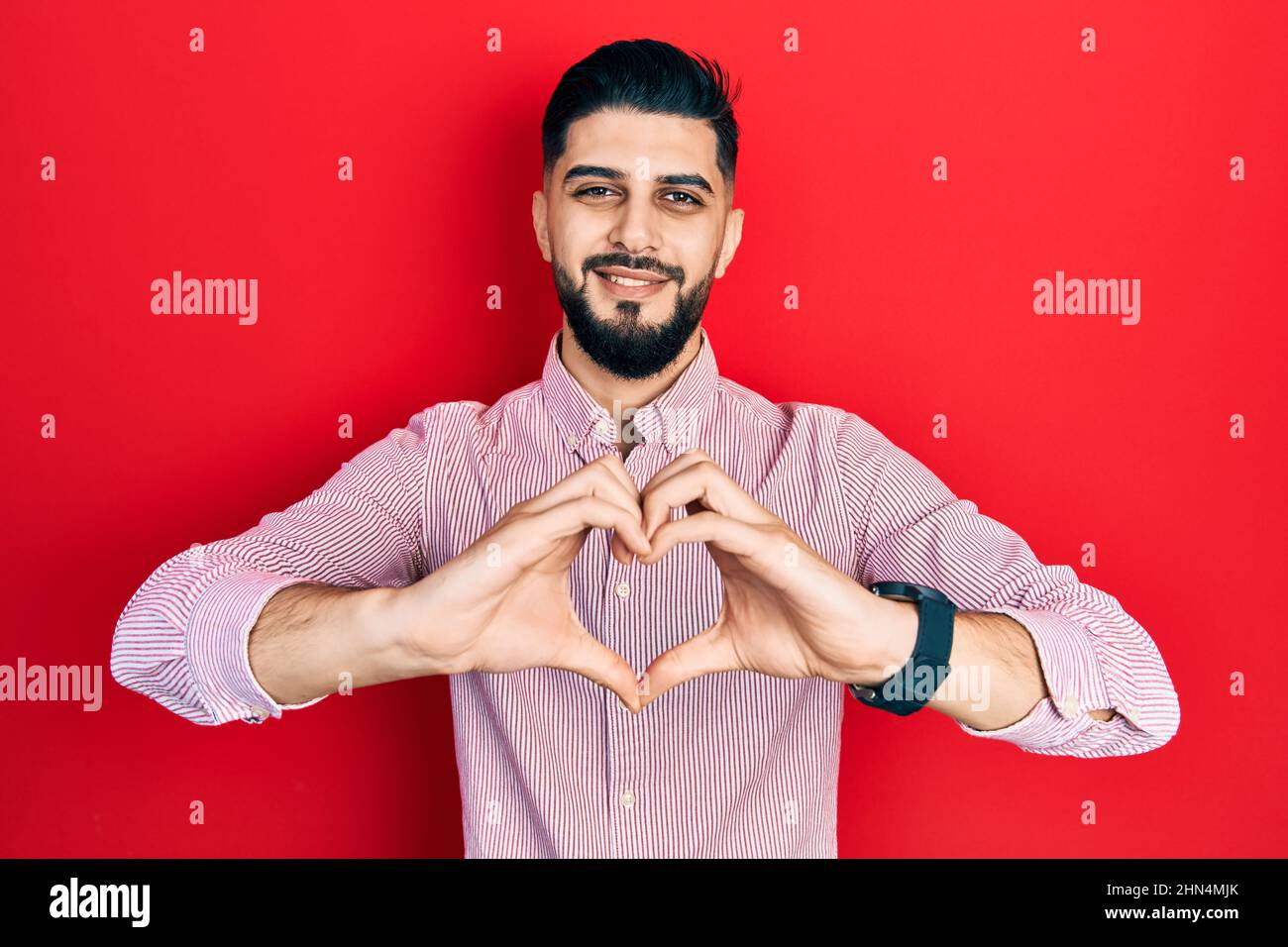 Handsome man with beard wearing casual red shirt smiling in love ...