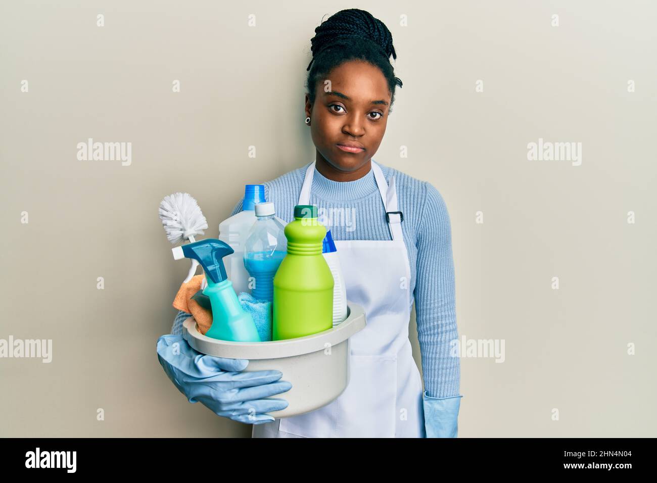 African american woman with braided hair wearing apron holding cleaning ...