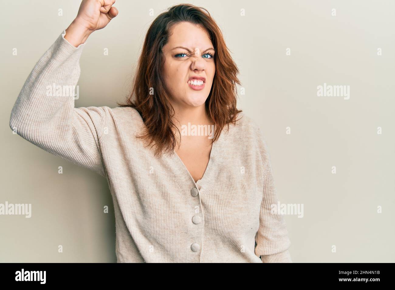 Young caucasian woman wearing casual clothes angry and mad raising fist ...