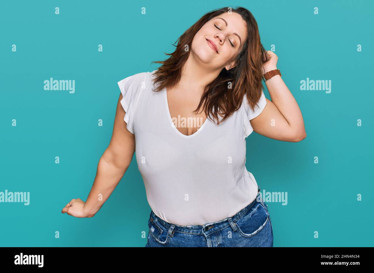 Young Plus Size Woman Wearing Casual White T Shirt Stretching Back