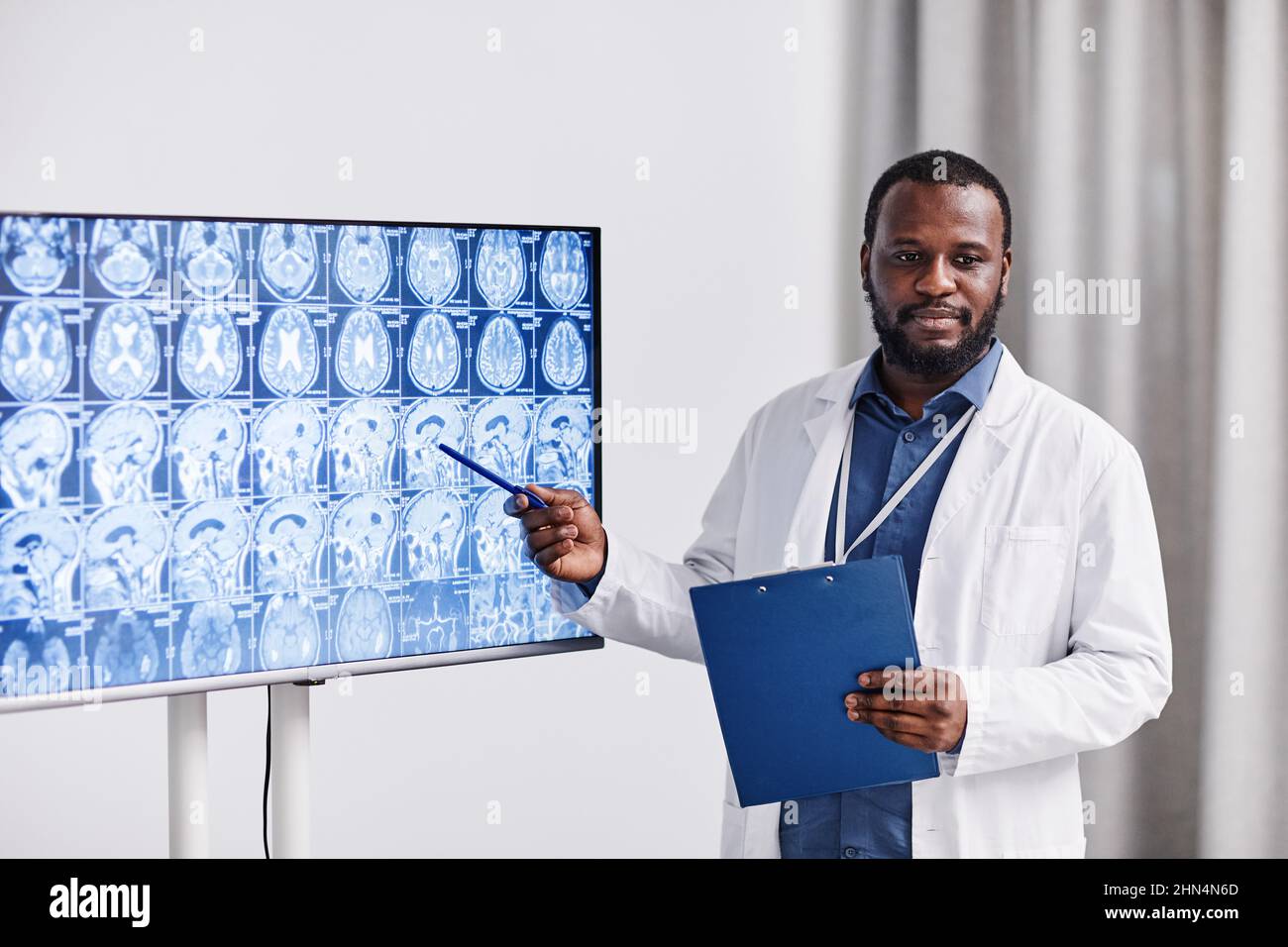 Young confident African-American medical officer pointing at brain scan ...