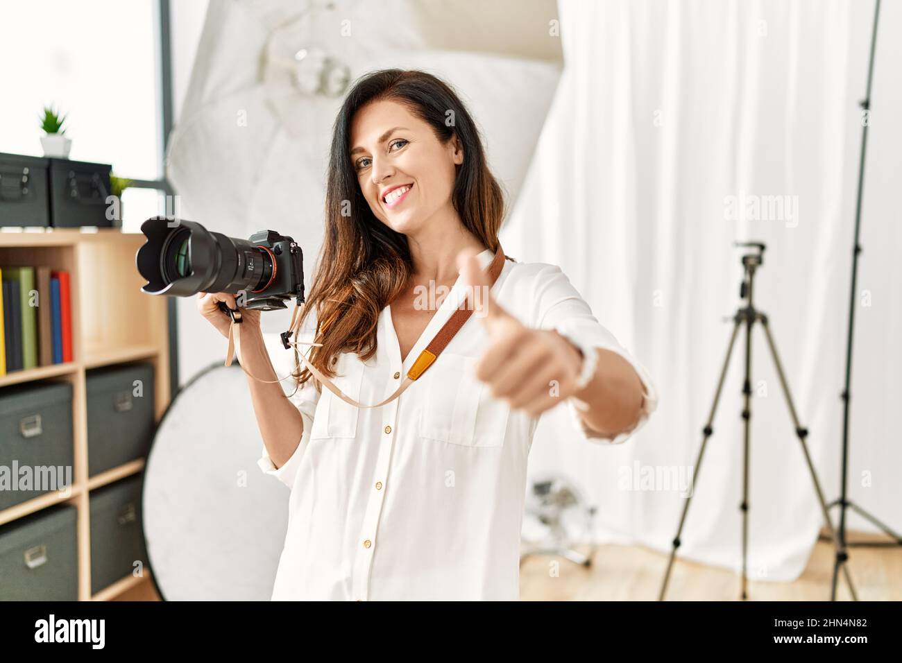 Beautiful caucasian woman working as photographer at photography studio ...